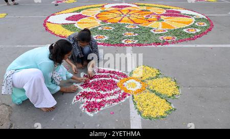 Women creating rangoli patterns from the petals of flowers, to ...