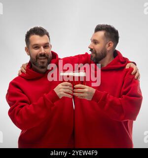 Two brothers, twins, dressed matching casual outfits, having fun ...