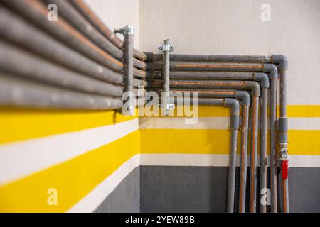 Detailed view of metal pipes installed on a wall with yellow and white ...