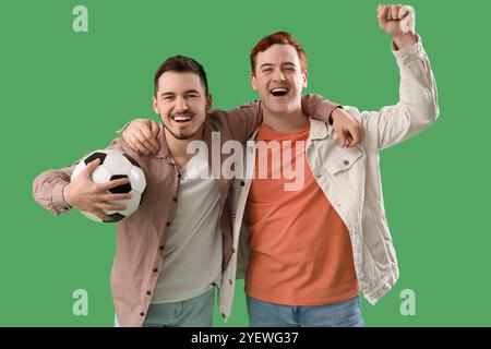 Male friends with soccer ball hugging on white background Stock Photo ...