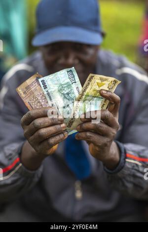 Microfinance borrower holding bank notes in a village near Huye ...