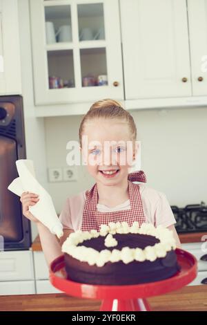 Kid, baker and excited with cake, happy and confident with child ...