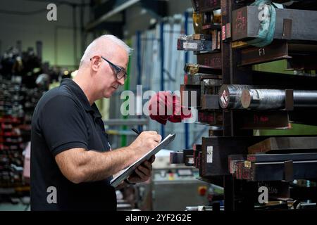 Metalworker measuring custom mechanical parts in metallurgy fabric ...