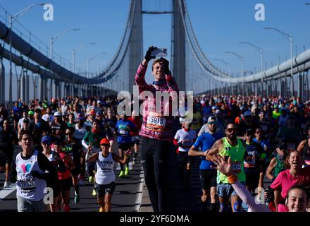 A runner on the on the Verrazzano-Narrows Bridge jogs by a view of a ...