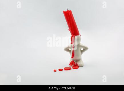 Red candle stub in cute candlestick in the shape of a man closeup on ...