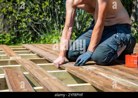Deck construction, builder hand with electric screwdriver installing ...