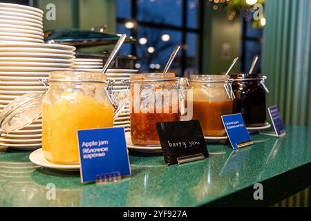 Jars of homemade jams and honey in glass jars and a variety of cheeses ...