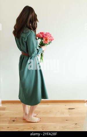 Photo of Beautiful woman with flowers peony in studio on pink ...