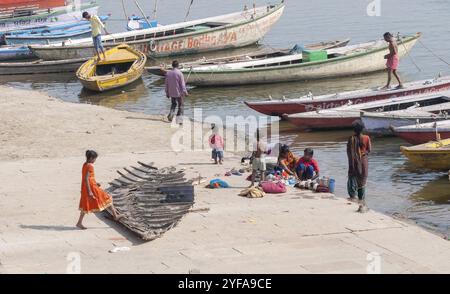 Varanasi, India, March 12, 2017: People and colourful boats at the bank ...