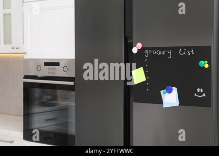 Magnetic board with grocery list and notes on refrigerator in kitchen ...