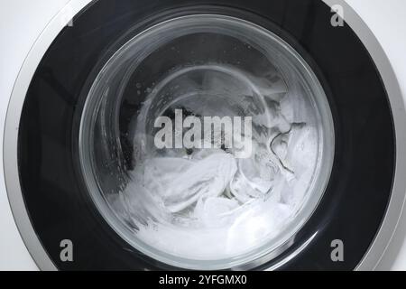 Washing machine with clothes and suds as background, closeup Stock ...