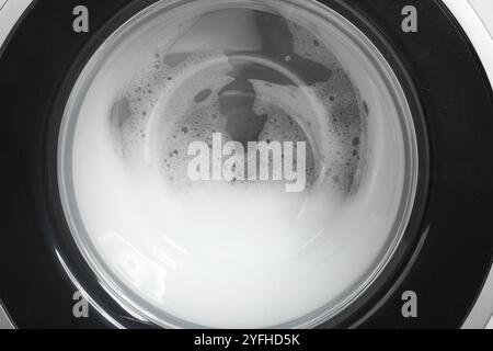 Washing machine with suds as background, closeup. Space for text Stock ...