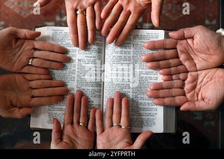 Group of people praying with Holy Bible at home Stock Photo - Alamy