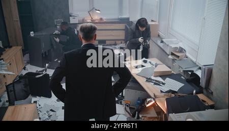 Office robbery case: High angle of detective examining crime scene ...