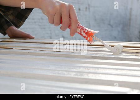 Carpenter applying a coat of paint to the wooden box Stock Photo - Alamy