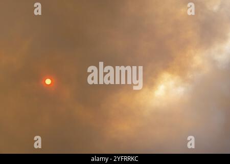 Cloud of smoke from large forest fire passing in front of sun ...