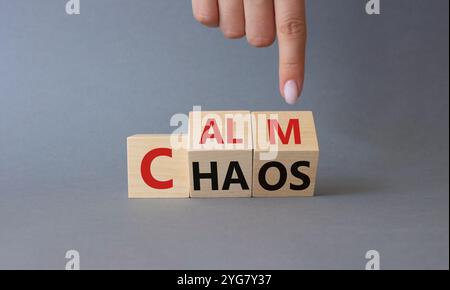 Calm vs chaos symbol. Businessman hand points at turned wooden cubes ...
