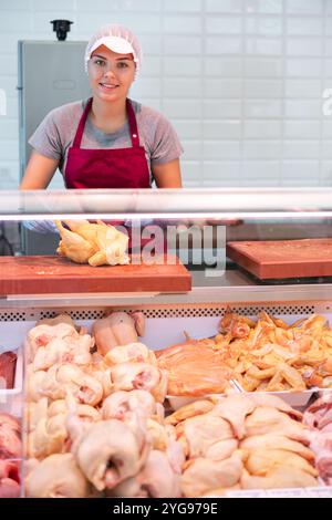Female seller took out dressed chicken carcass from case refrigerator ...