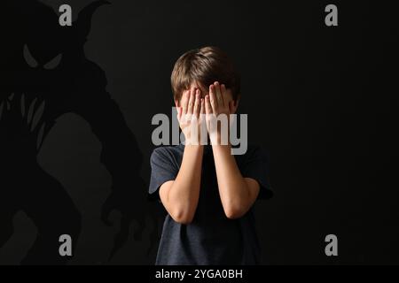 Frightened by monsters, boy covering his eyes, teraphobia. Creepy ...