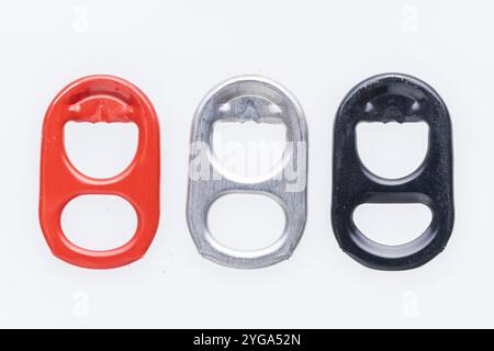 Three can pull tabs, one red, one silver, and one black, are arranged ...