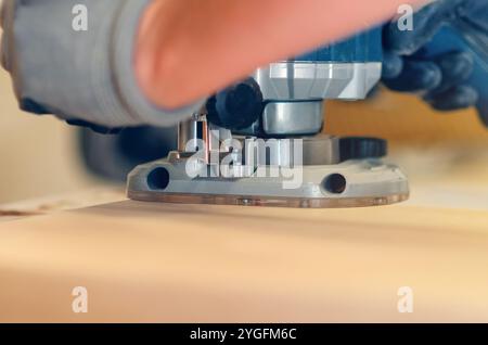 Close-up of a hand router smoothing wooden board edges, precision ...
