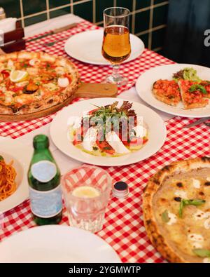 Italian Restaurant Table Spread with Various Pizzas, Pasta Dishes, and ...