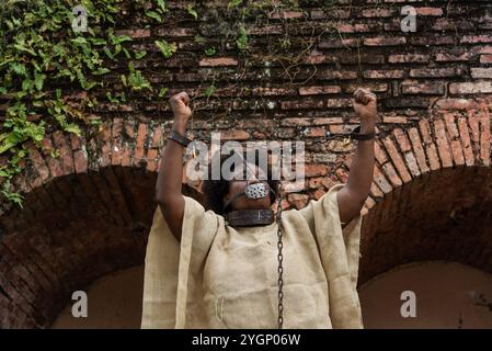 Black woman dressed as a slave, chained and with an iron mask over her ...