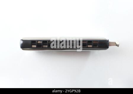 Metal and plastic chromatic harmonica isolated on white table. Top ...