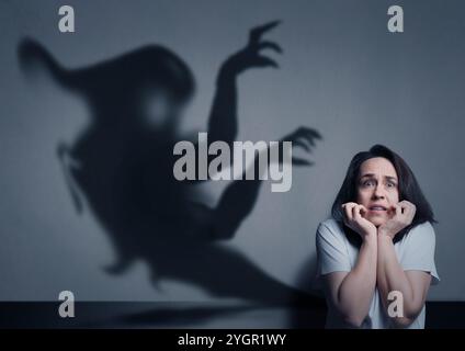 Woman scared by monster. Scary shadow in room Stock Photo - Alamy