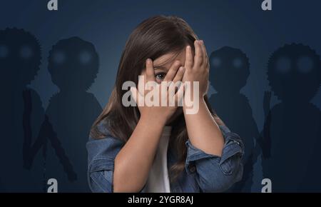 Teraphobia - fear of monsters. Scared girl covering her eyes on grey ...