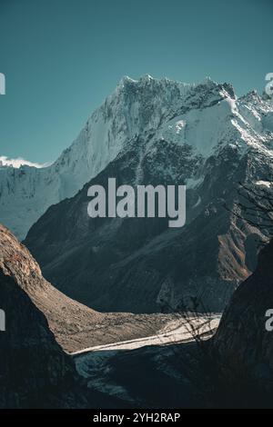 Dramatic landscape with snowy peaks rising above brown hills and ...