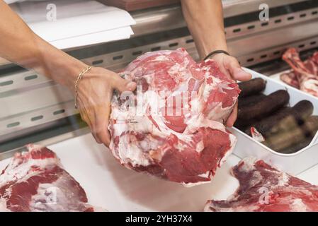 Butcher offering fresh meat at display in butchery Stock Photo - Alamy