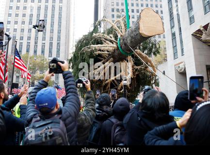 Spectators watch as workers lift into place by crane the Rockefeller ...