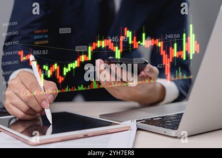 A businessman holding a tablet with forex trading graph-stock market ...