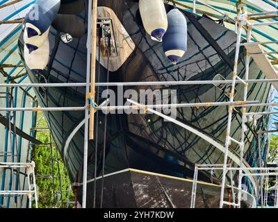 A boat is carefully lifted under a covered structure Stock Photo - Alamy