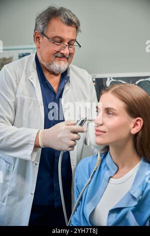 Male doctor with help of nurse performs rejuvenation procedure for ...