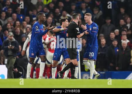 Chelsea players surround referee Michael Oliver after Arsenal's Kai ...