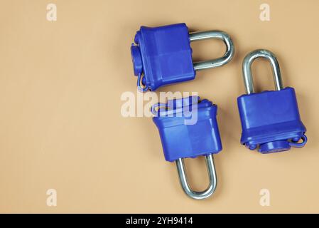 Padlock with blue plastic insulation and key, on a beige background ...