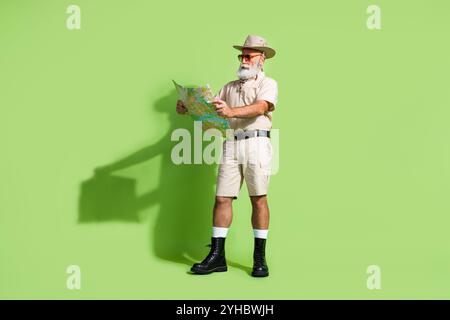 Focused male explorer reading map while searching for trail during ...