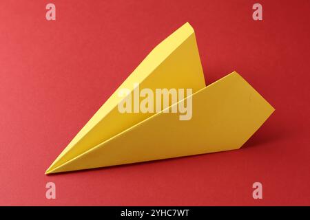 Yellow paper plane on red background Stock Photo - Alamy