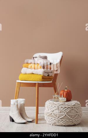 Warm sweaters on pouf near color wall Stock Photo - Alamy