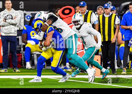 Miami Dolphins linebacker Quinton Bell, left, signs autographs for fans ...