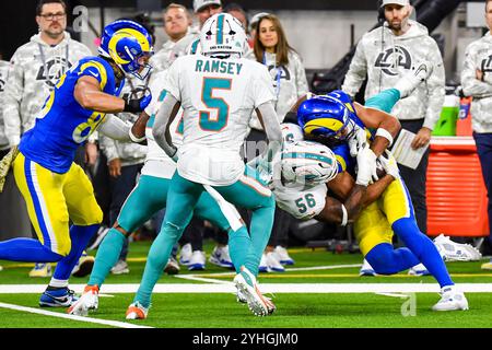 Miami Dolphins linebacker Quinton Bell, left, signs autographs for fans ...