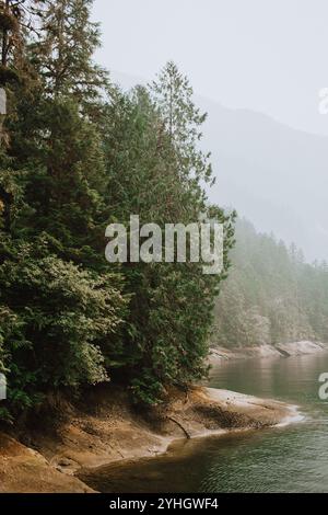 A scenic view of a rocky mountain enveloped in white clouds in a rural ...