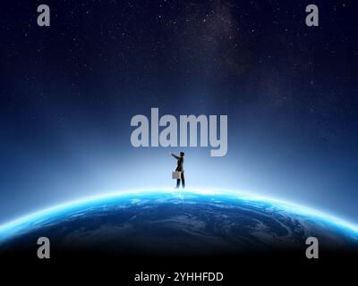 Businessman standing on Earth pointing his finger Stock Photo - Alamy