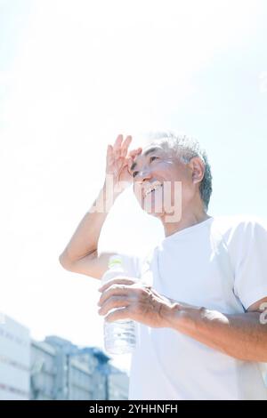 Middle-aged man wiping off sweat with towel after working out at home ...