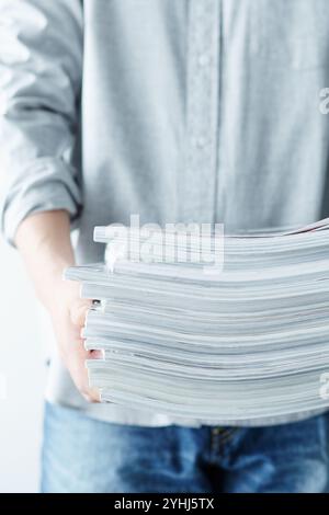 Person holding stack of magazines Stock Photo - Alamy