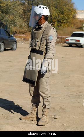 Mine clearing. Bomb disposal expert using a magnetometer to find mines ...