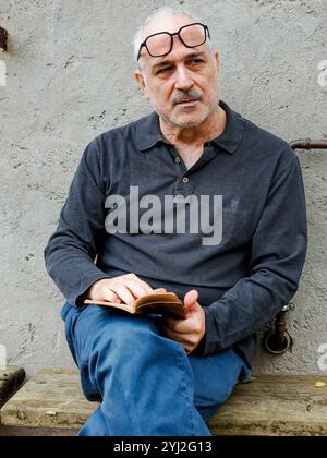 Thoughtful mature man sitting on sofa in office Stock Photo - Alamy