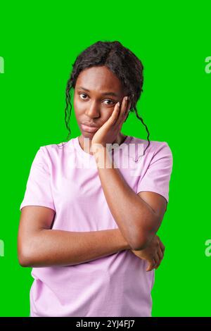 Young woman with an expression of contemplation poses against a bright ...